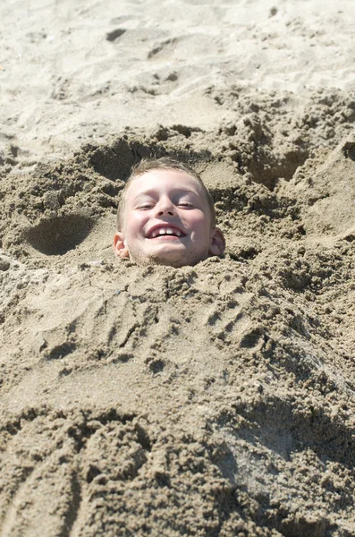 Child buried in the sand Stock Photo by ©Gelpi 9433393