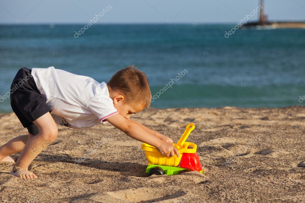 Child pushing his car toy on Lanzarotes beach Stock Photo by ...