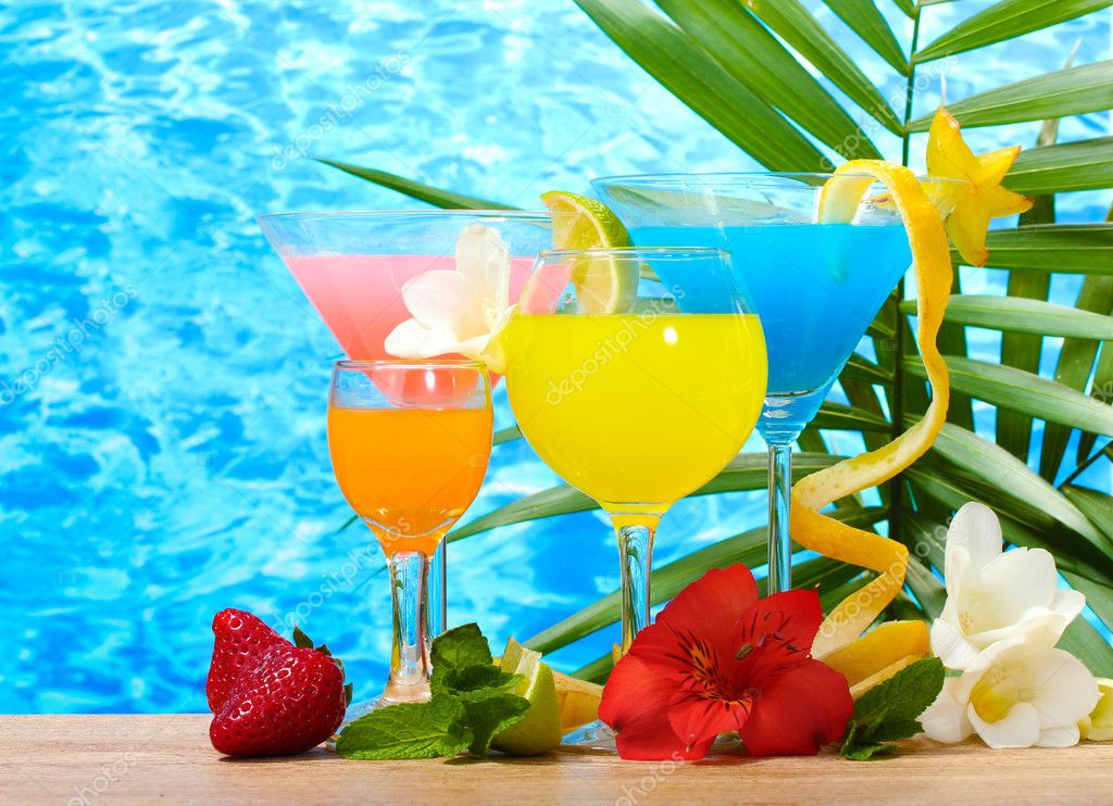 Exotic cocktails and flowers on table on blue sea background Stock ...