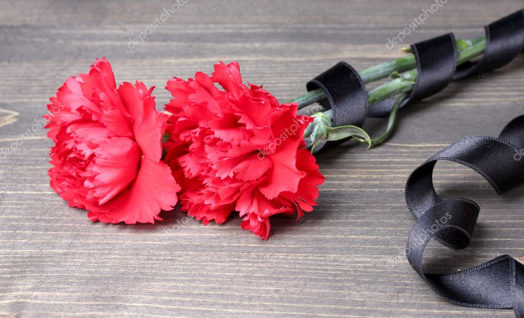 Carnations and black ribbon on grey wooden background Stock Photo by ...