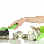 Sweeps money in the shovel on wooden background close-up Stock Photo by ...