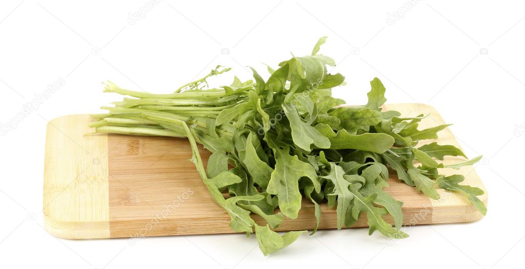 Fresh rucola salad or rocket lettuce leaves on wooden board isolated on ...