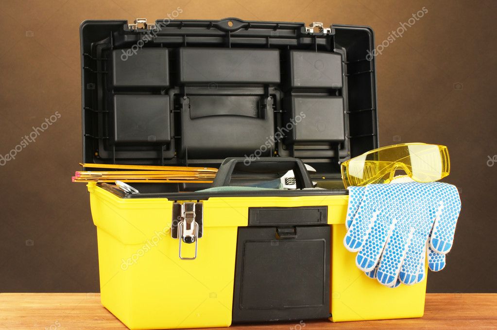 Open yellow tool box with tools on brown background close-up Stock ...