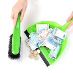 Sweeps money in the shovel on wooden background close-up Stock Photo by ...