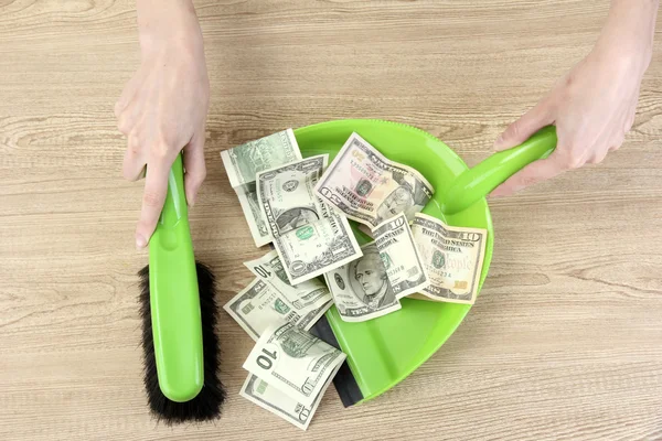 Sweeps money in the shovel on wooden background close-up Stock Photo by ...