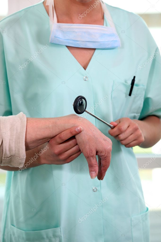 Doctor checking his patient's reflexes — Stock Photo © photography33 ...