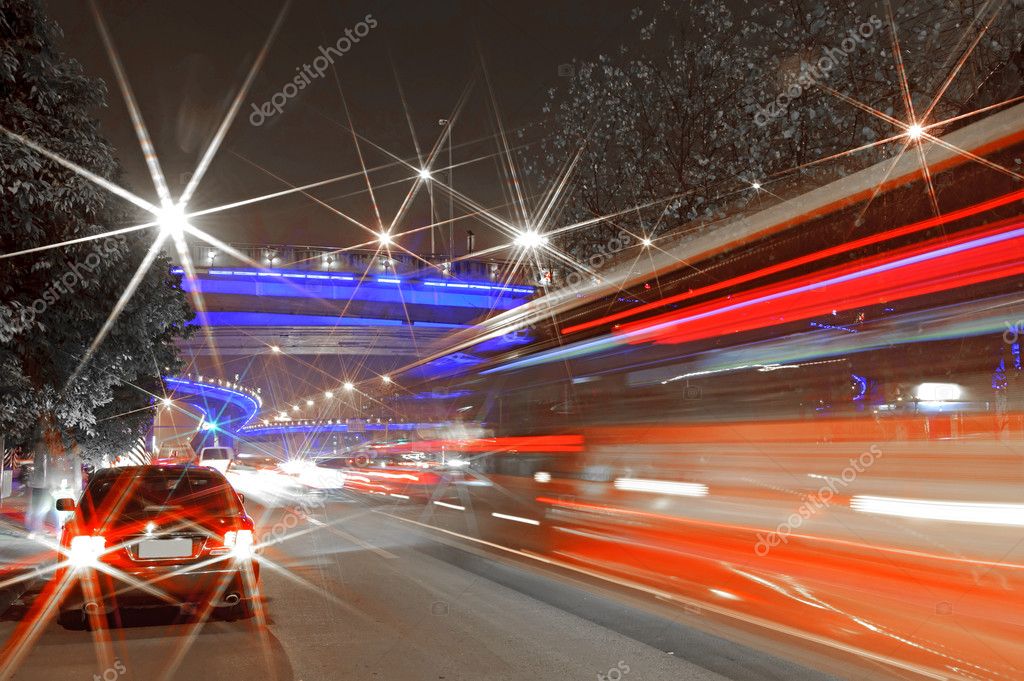 High-speed vehicles blurred trails on urban roads under overpass ...