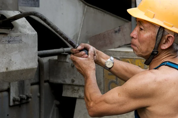 Hardworking laborer and truck-concrete mixer on construction site ...