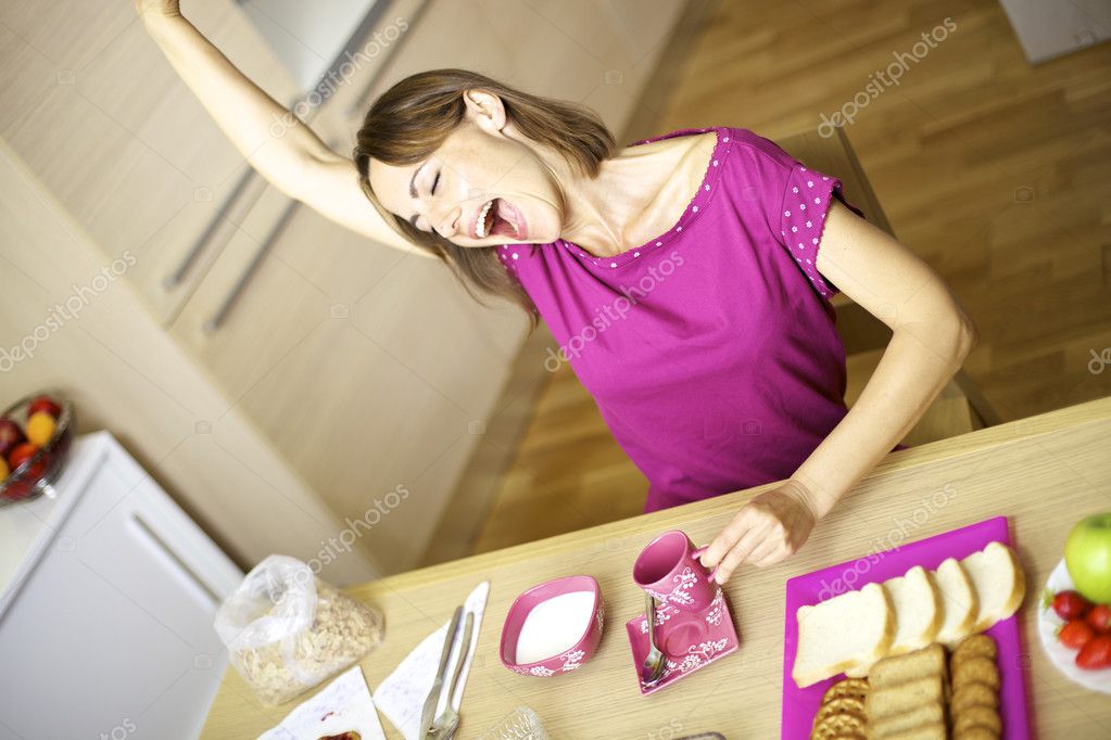 Beautiful female model in pajamas yawning during breakfast Stock Photo ...