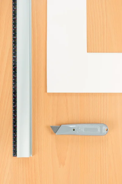 Handheld mat cutter kit. Rule guide knife on wooden background - Stock ...