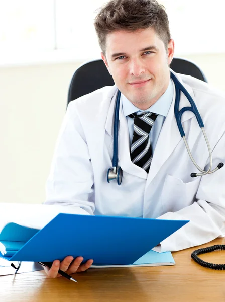 Self-assured doctor reading a report - Stock Image - Everypixel