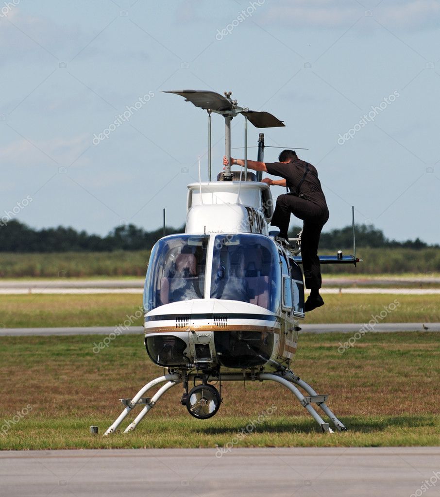 Pilot preparing police helicopter for flight — Stock Photo ...