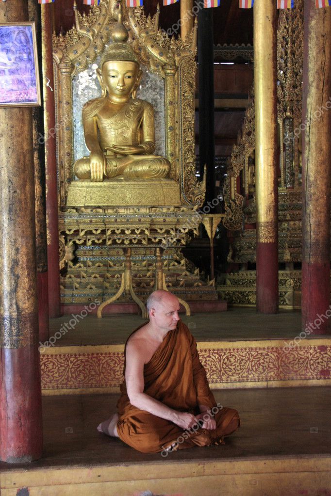 Monk sitting near statue of Buddha, Jumping cat Monastery, Inle lake ...